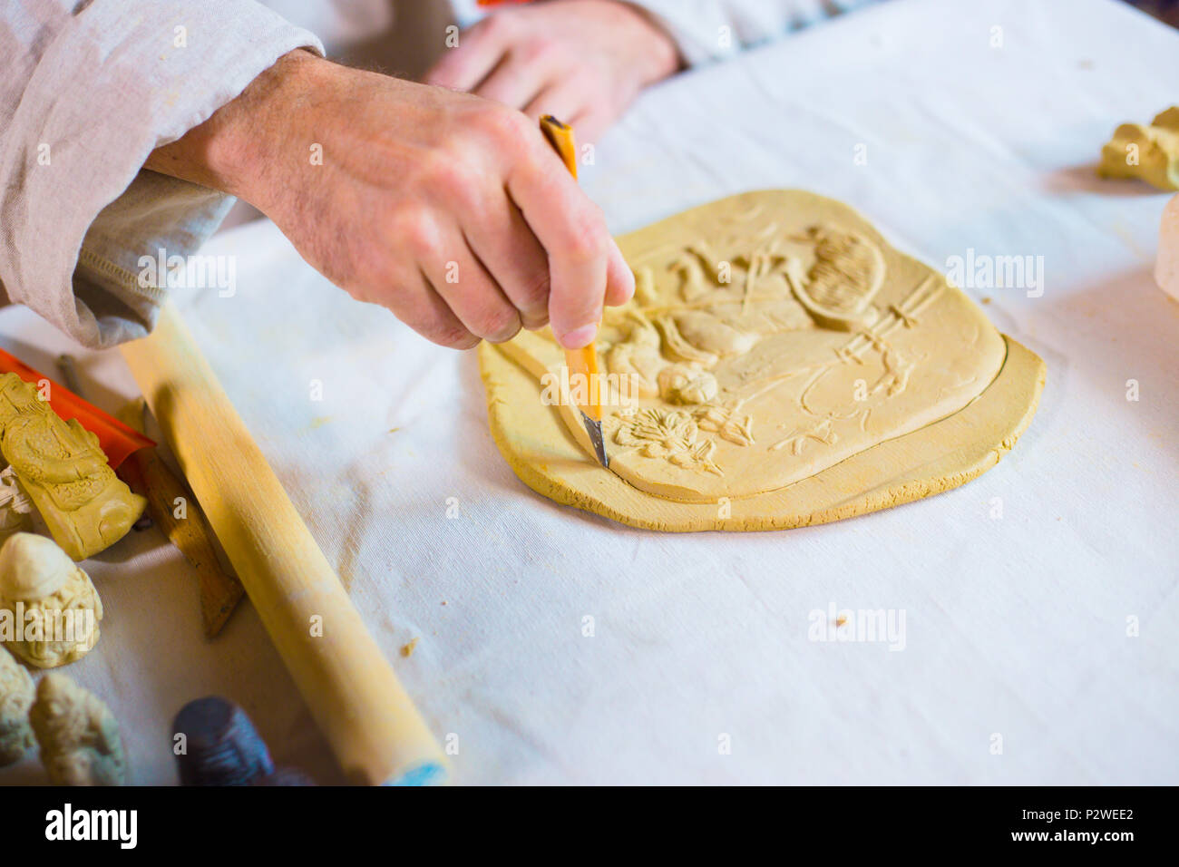 Professional male potter making clay stamp picture. Handwork, crafting ...