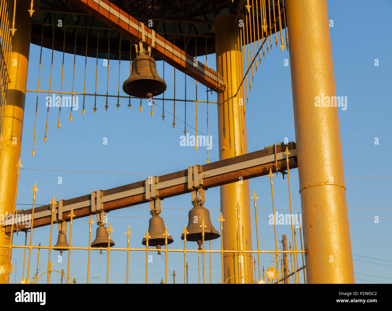 Christian belltower with wooden crossbar bronze bells golden cross and ...