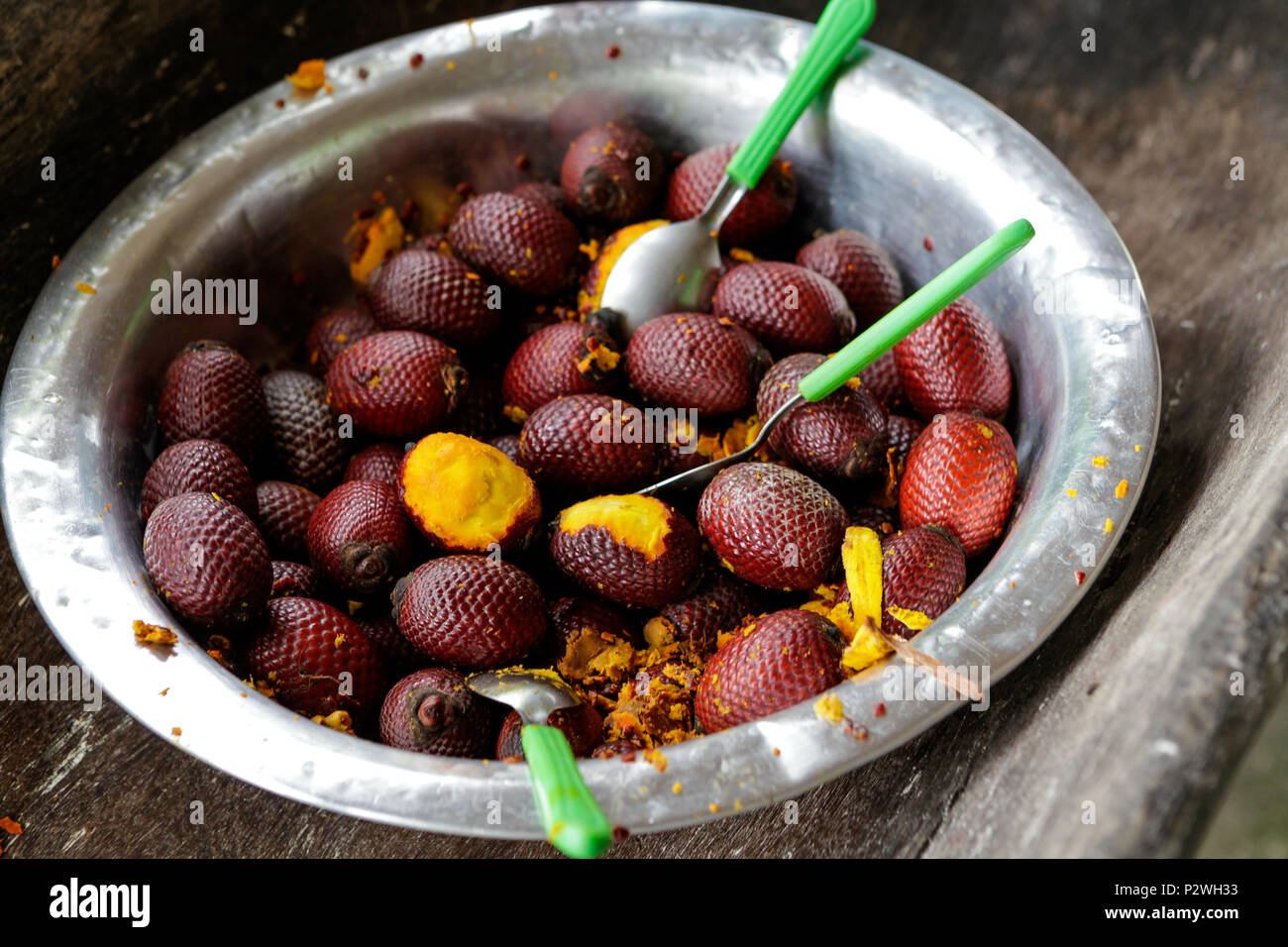 Close up of fresh "buriti" fruit with spoons inside a metal bowl in ...