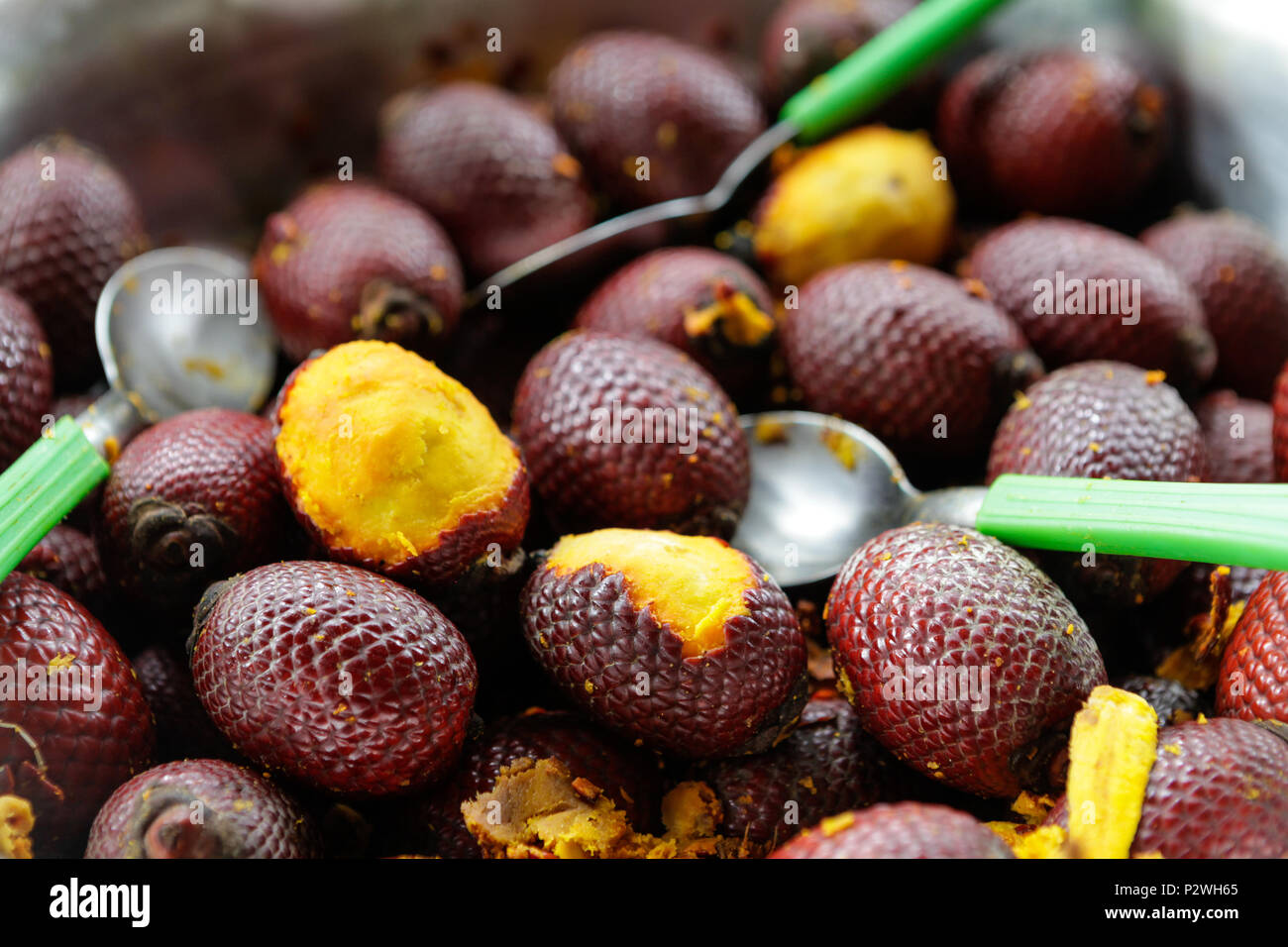 Close up of fresh "buriti" fruit with spoons inside a metal bowl in ...