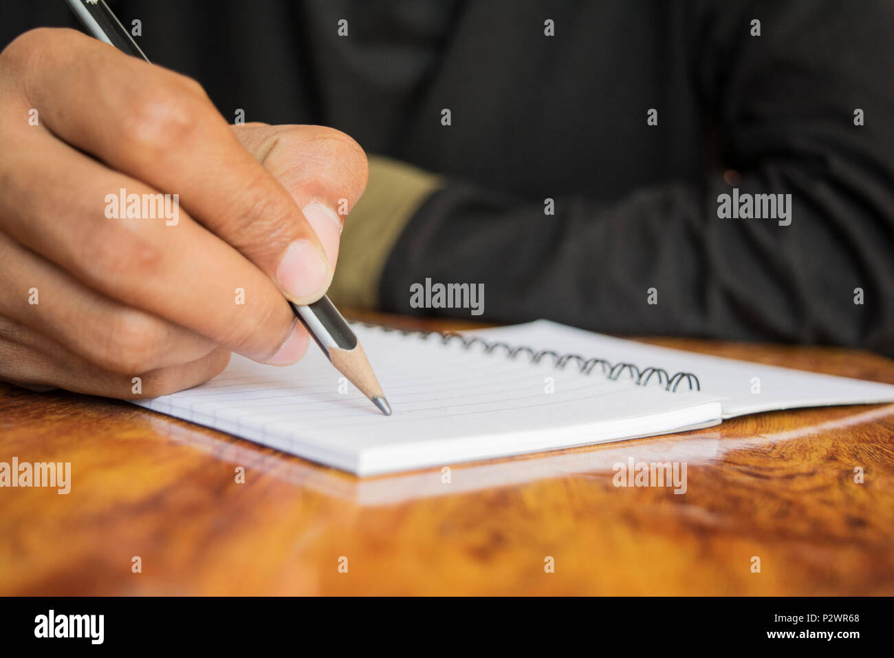 man writing a note with pencil Stock Photo - Alamy