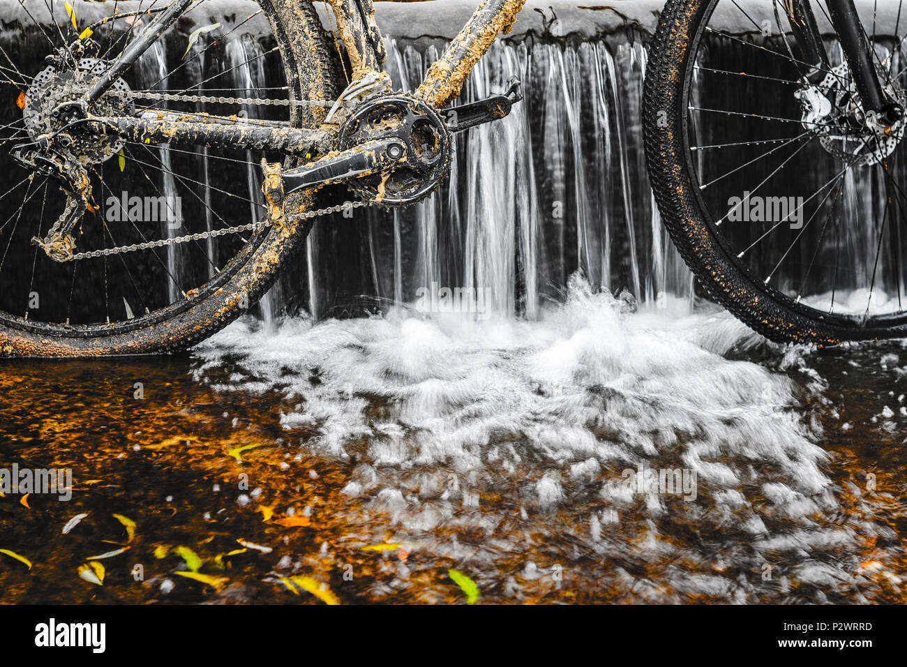 Dirty Mountain Bike Stands in a Creek Against the Small Waterfall ...
