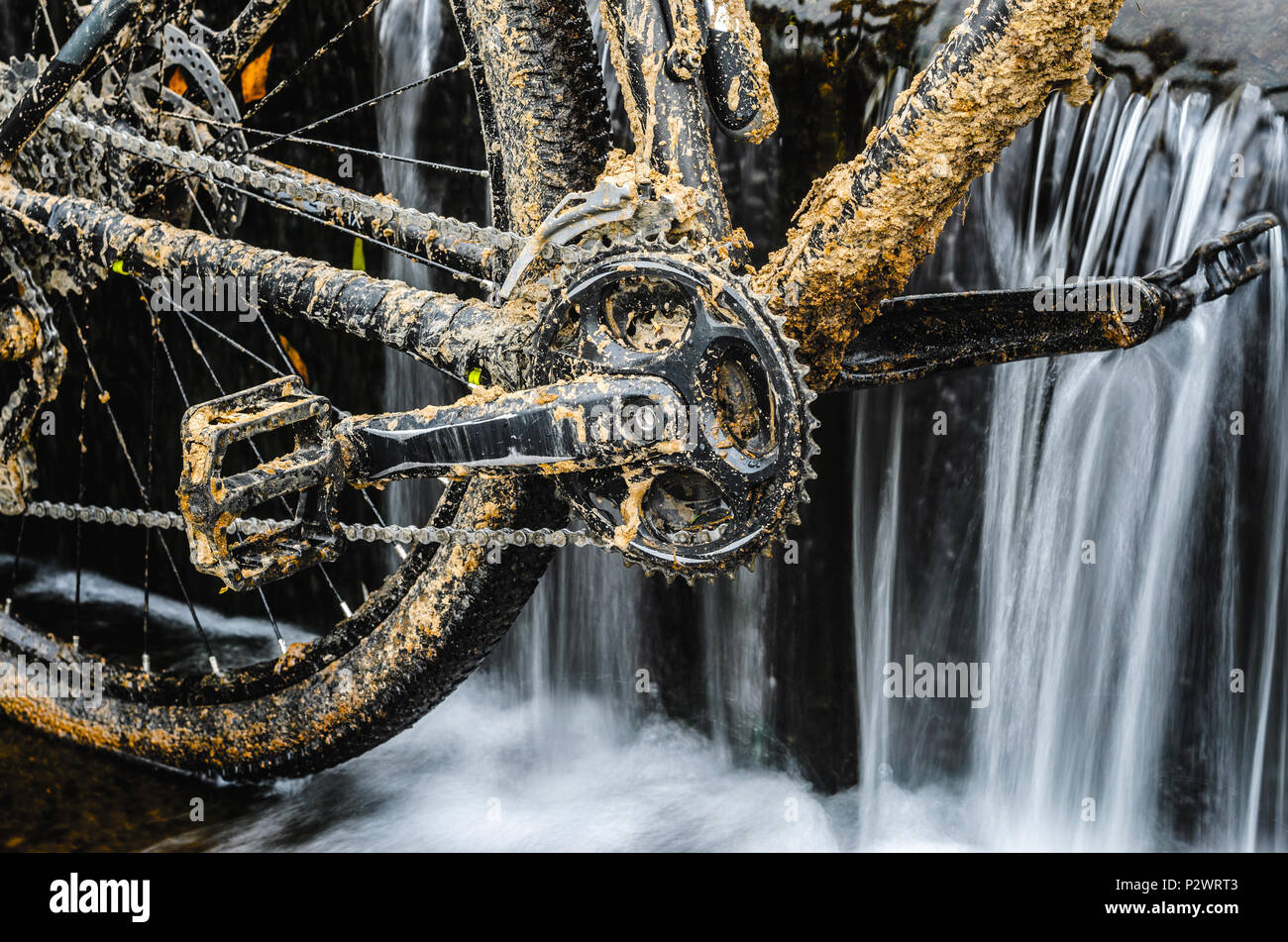 Dirty Mountain Bike Stands in a Creek Against the Small Waterfall ...