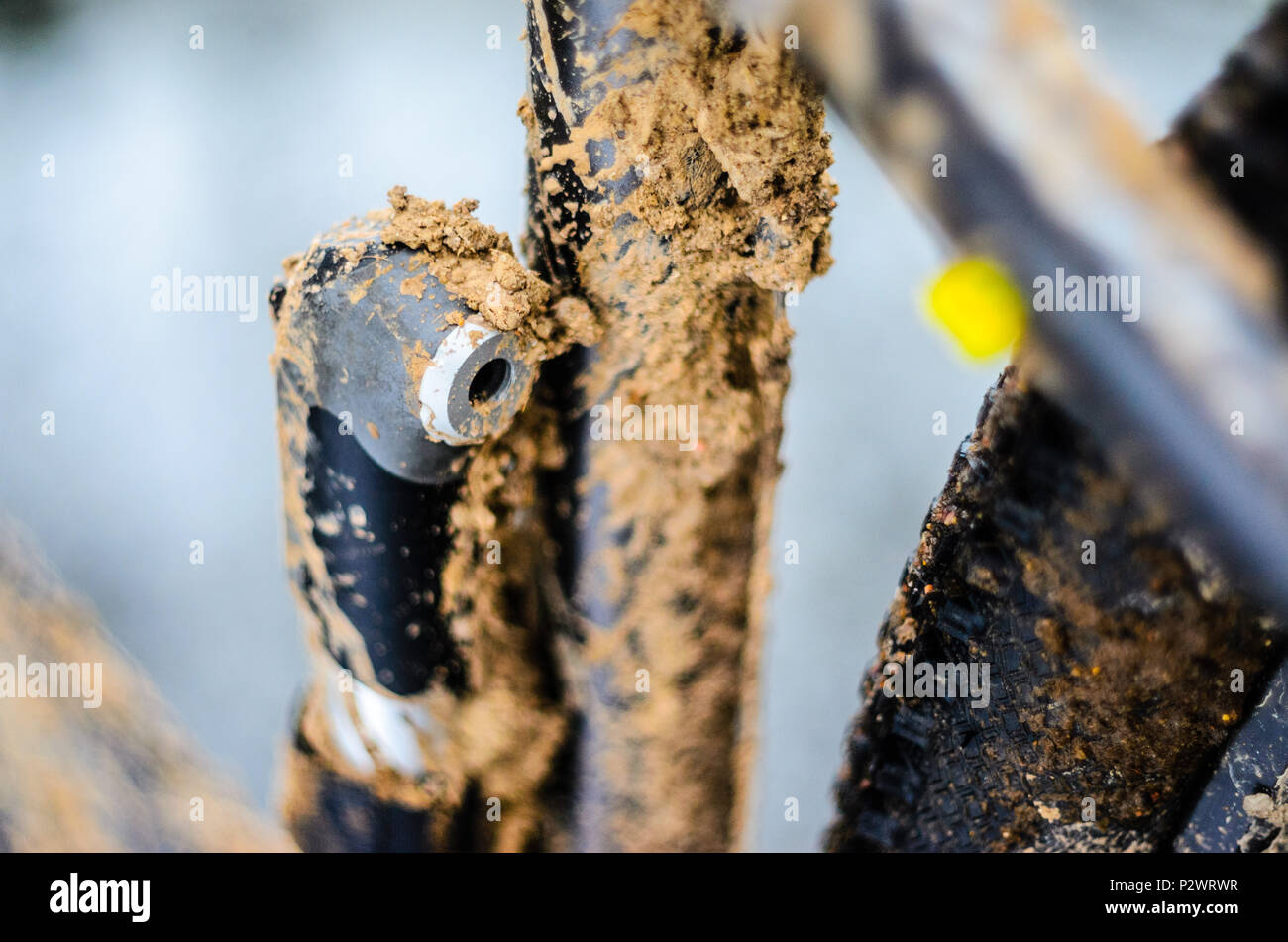 A bicycle in the mud. Elements of a mountain bike frame covered with ...