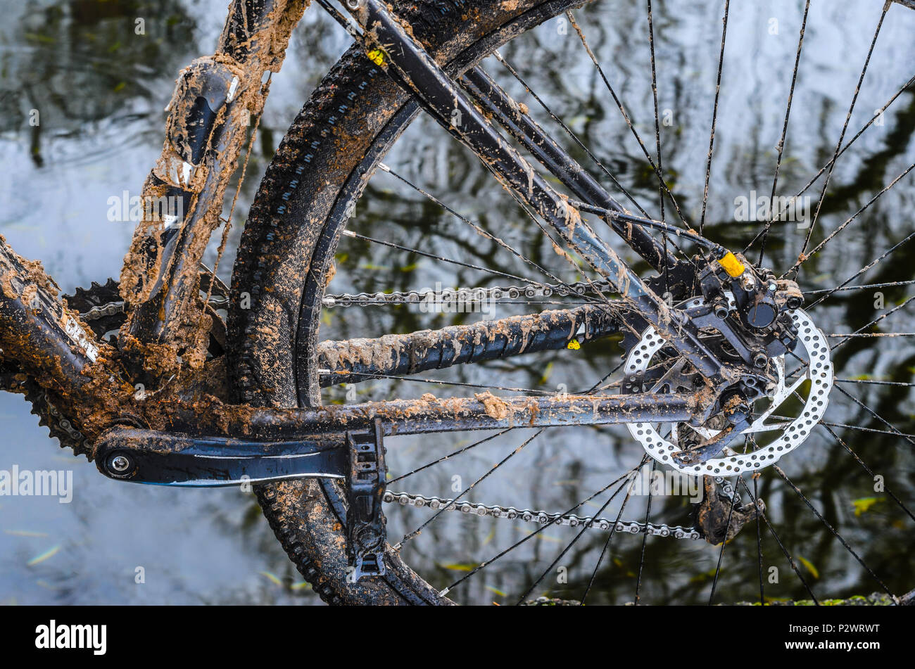 A bicycle in the mud. Elements of a mountain bike frame covered with ...