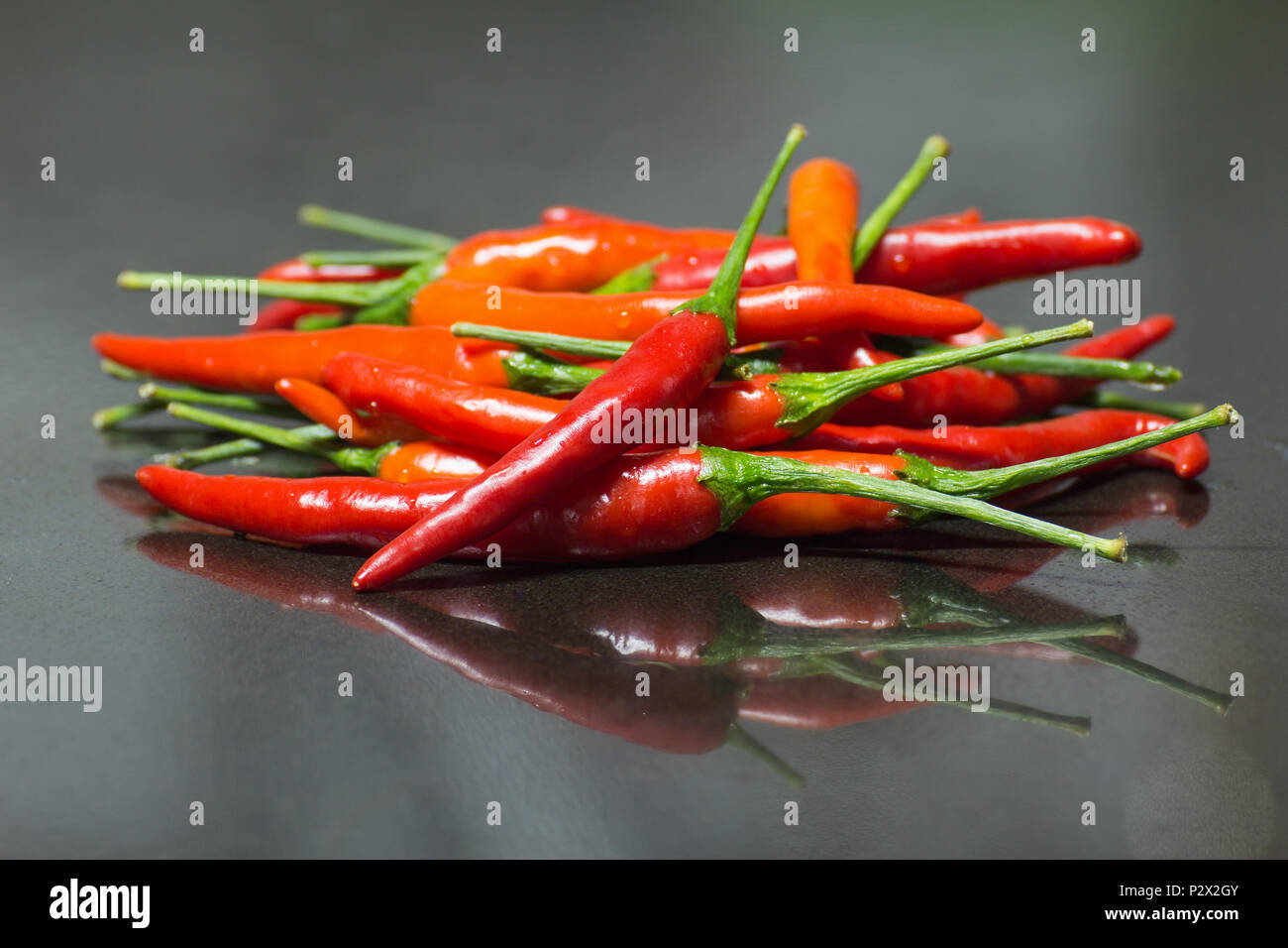 Fresh red chilli on black granite table background Stock Photo - Alamy