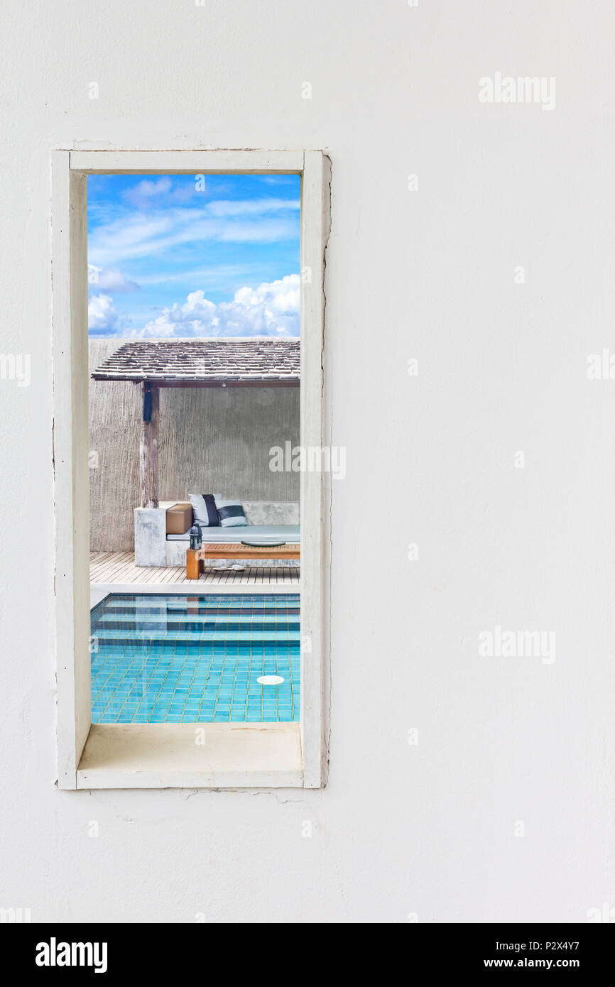 White wall window with swimming pool view, vertical landscape concept ...