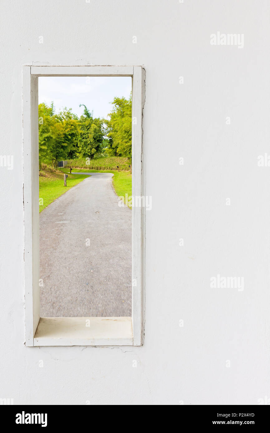 White wall window with walkway in garden view, vertical landscape ...