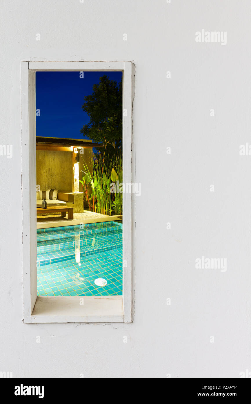 White wall window with swimming pool view, vertical landscape concept ...