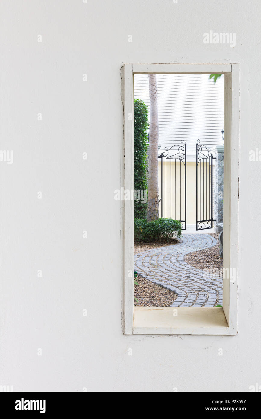 White wall window with walkway in garden view, vertical landscape ...