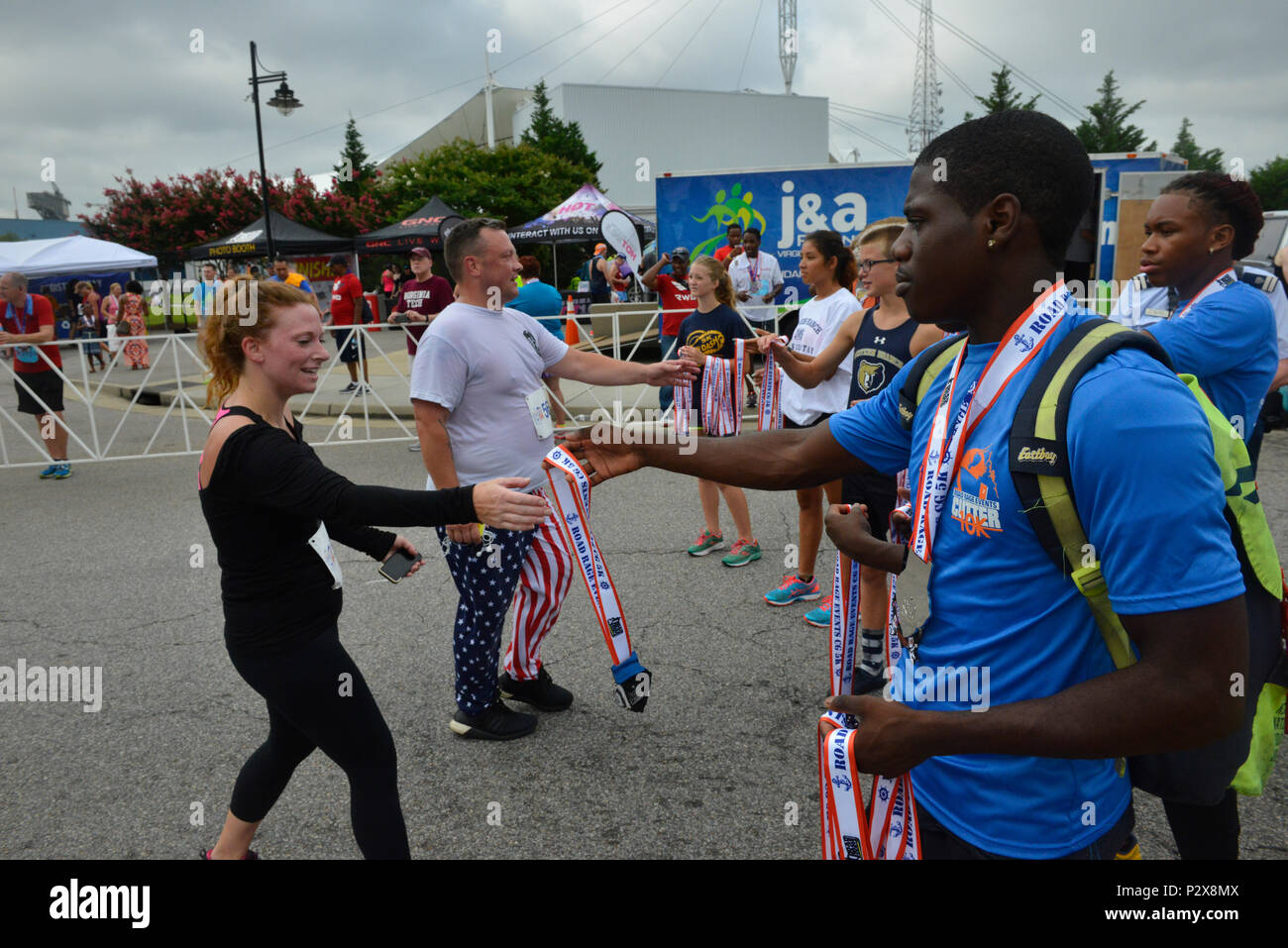 A runner in the Coast Guard 5K road race receives her finisher's medal ...