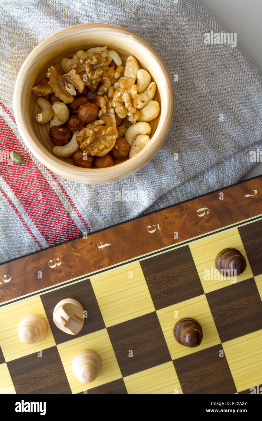 Healthy eating concept. Mix of dried fruits and nuts with chess pieces ...
