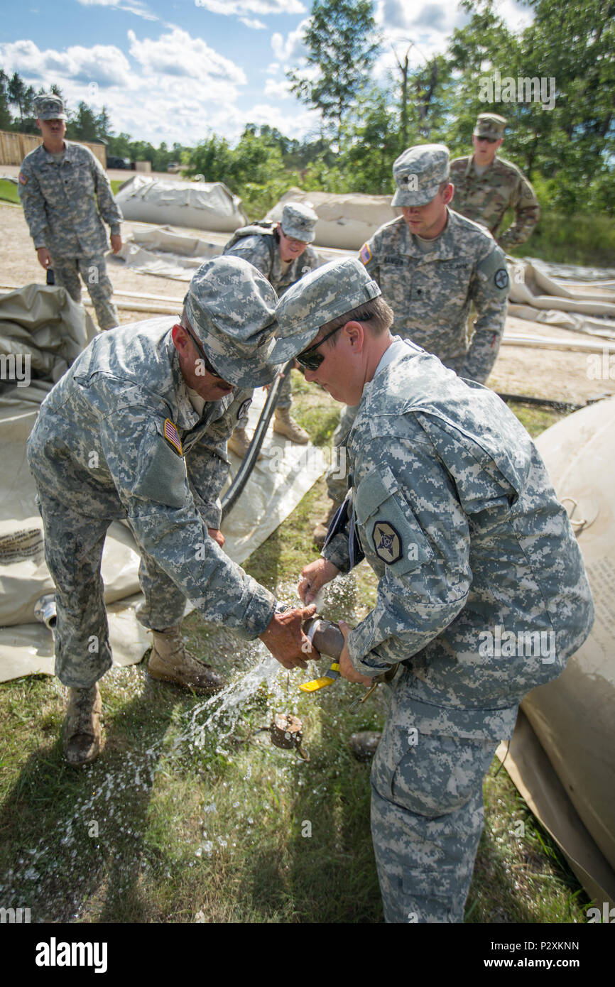 U.S. Army Soldiers of the 651st Quartermaster Company, Casper, Wyo., conduct water purification ...