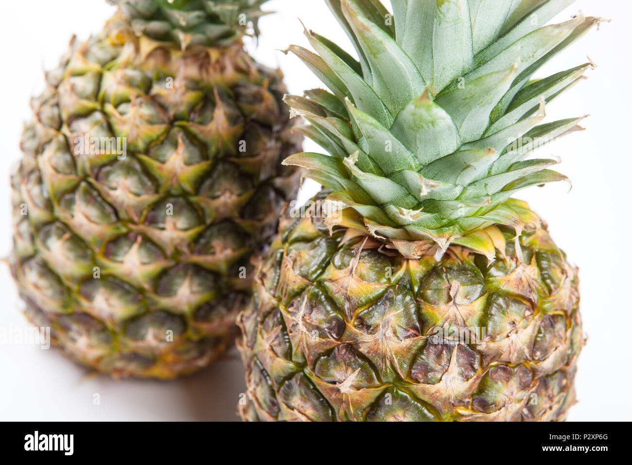 two big pineapples on a white background closeup Stock Photo - Alamy