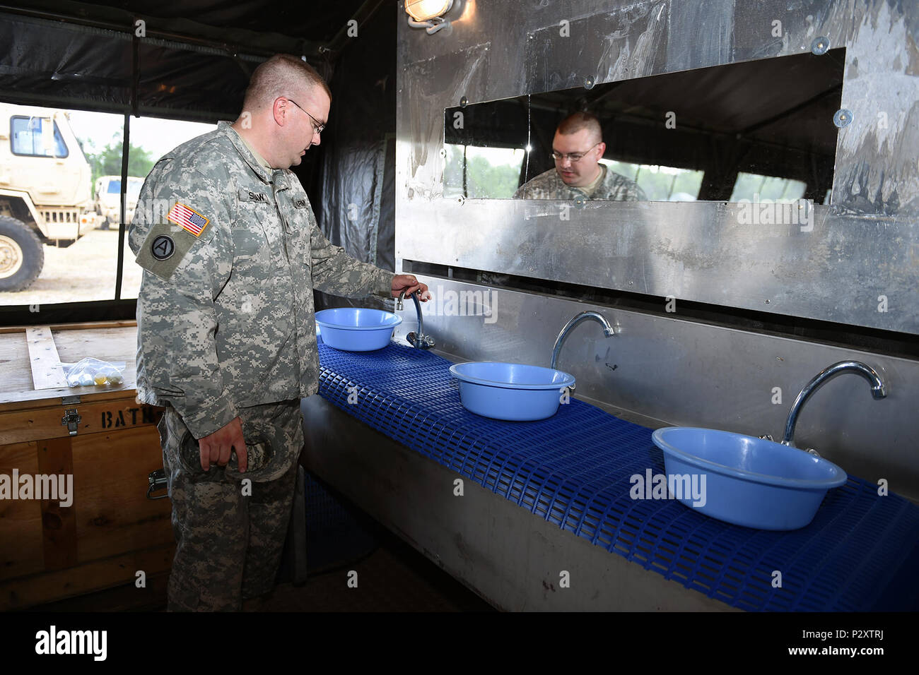 Sgt. Eric Shaw adjusts the sinks in the shower facility available at ...