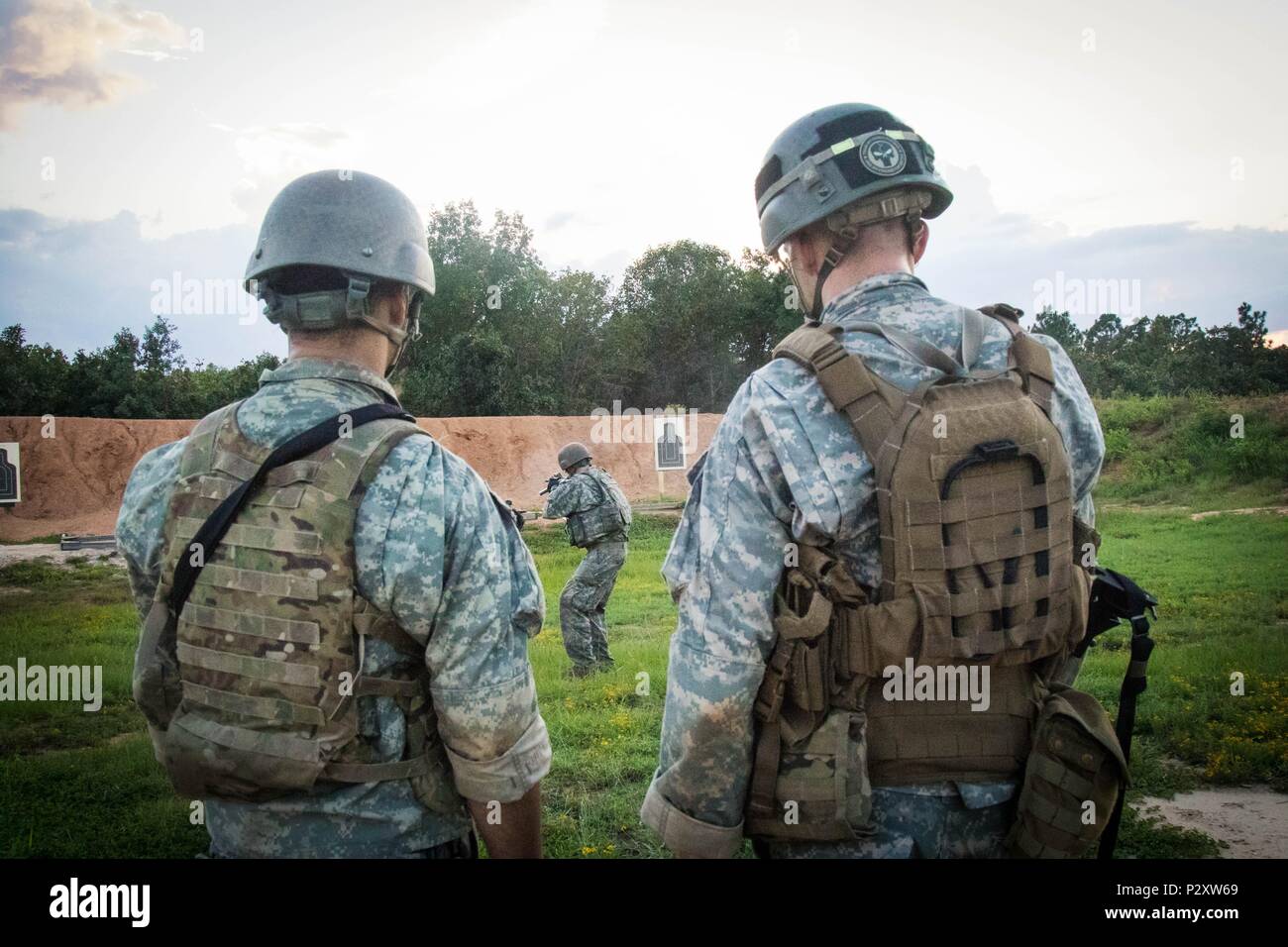 Two U.S. Army pathfinders observe as a fellow soldier shoots at a ...