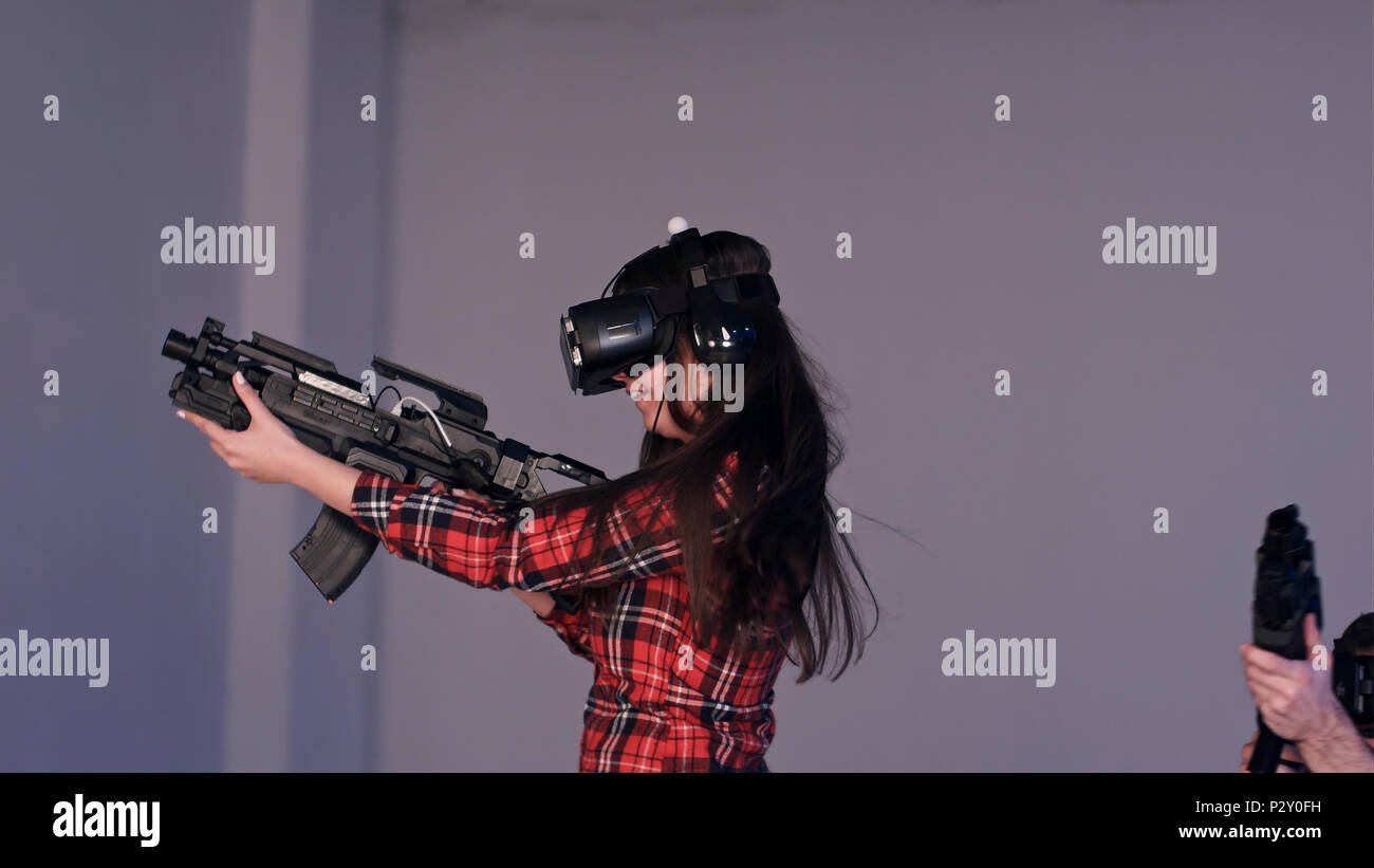 Excited young couple wearing VR goggles playing virtual reality shooter ...