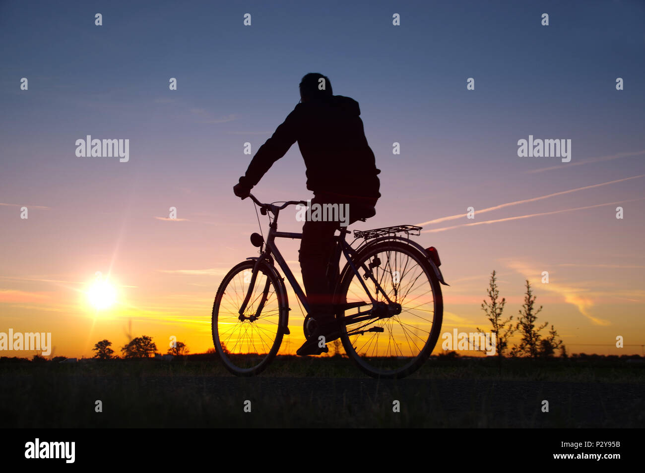 Man ride on bicycle. Rider silhouette on retro bike with sunset sky in ...