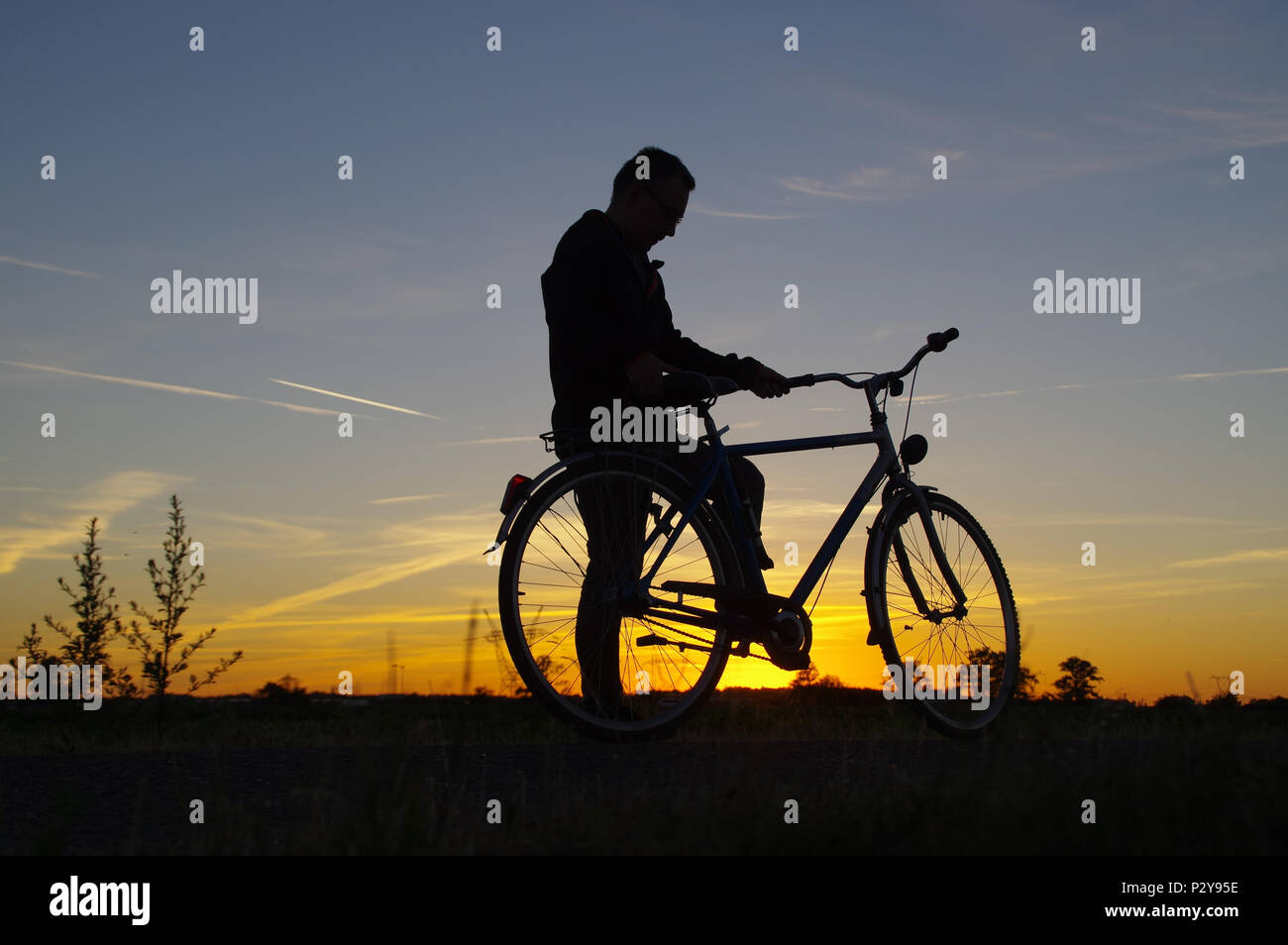 Man ride on bicycle. Rider silhouette on retro bike with sunset sky in ...