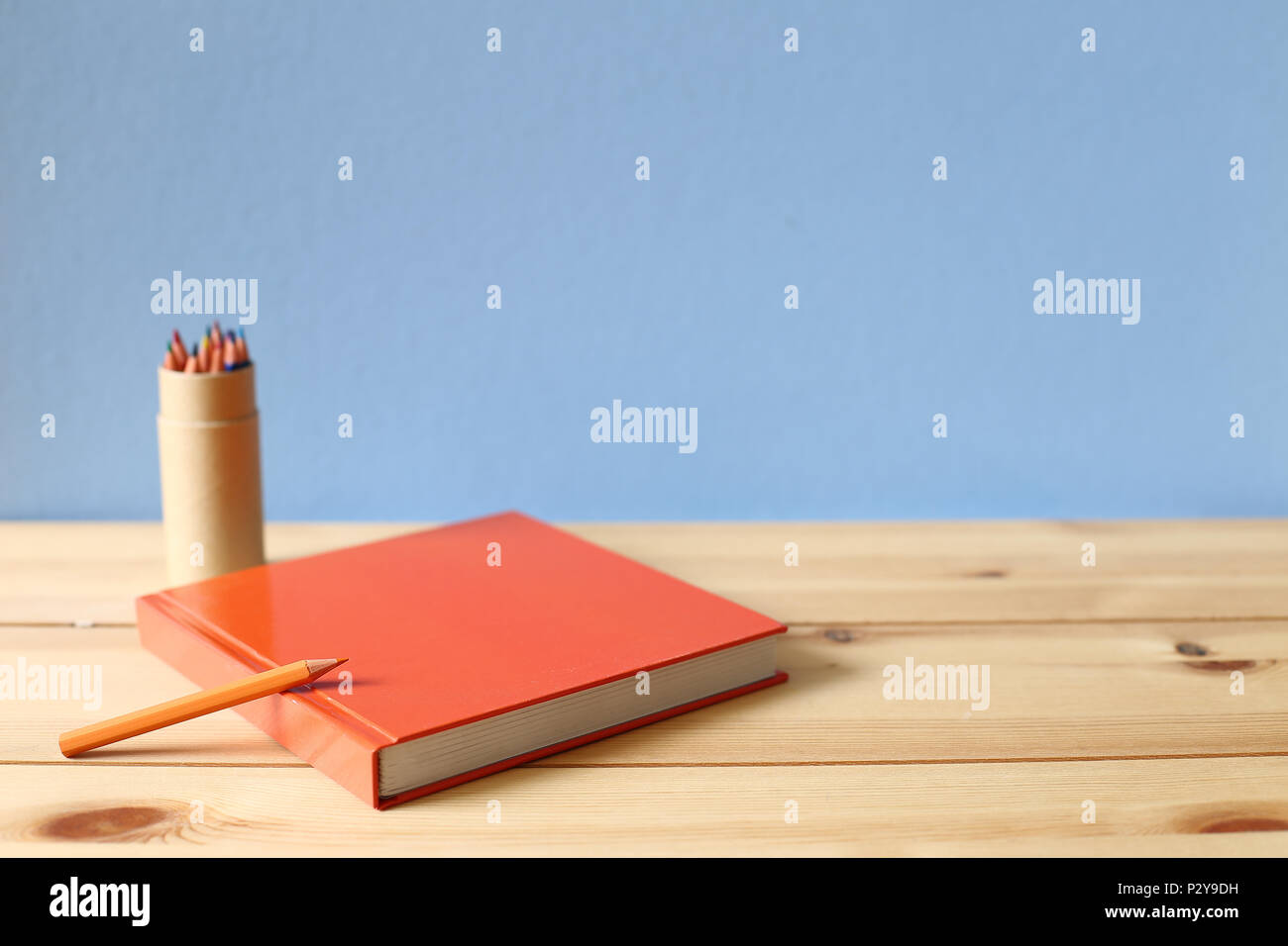 Notebook and colored pencil on wooden desk Stock Photo - Alamy