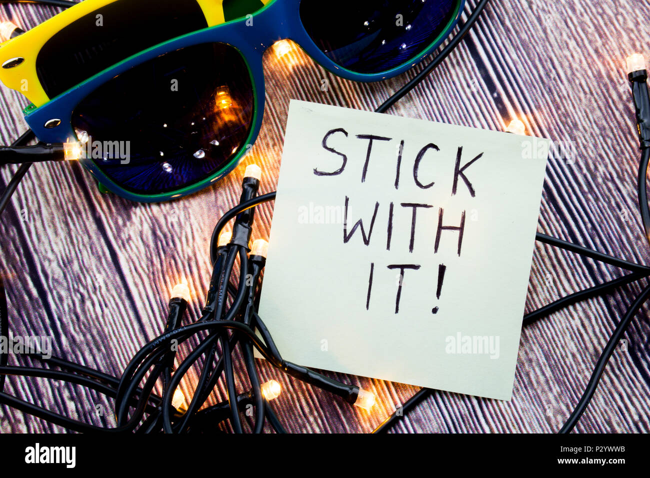 Stick with it motivational concept in business on notepaper. Two ...