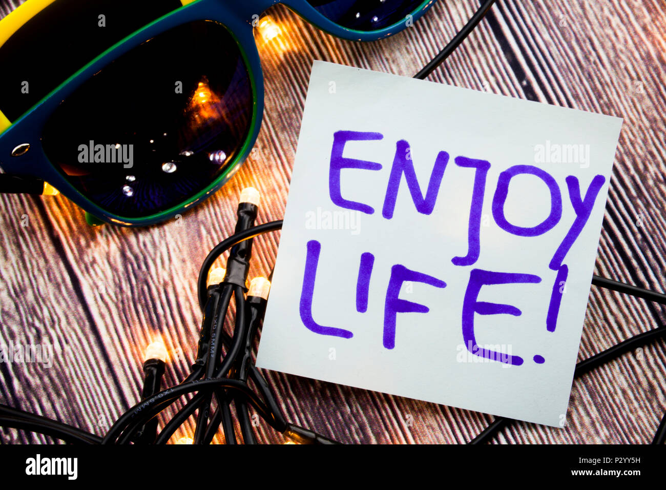 Enjoy life motivational handwritten message on paper with blue color on ...