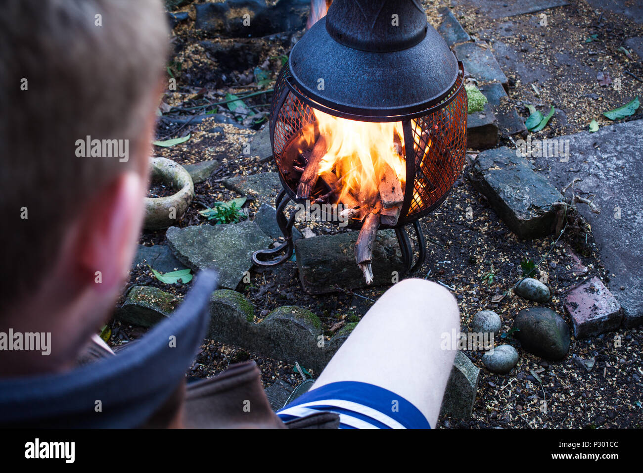 Man sitting in front of the fire. Open blaze with Bbq concept with ...