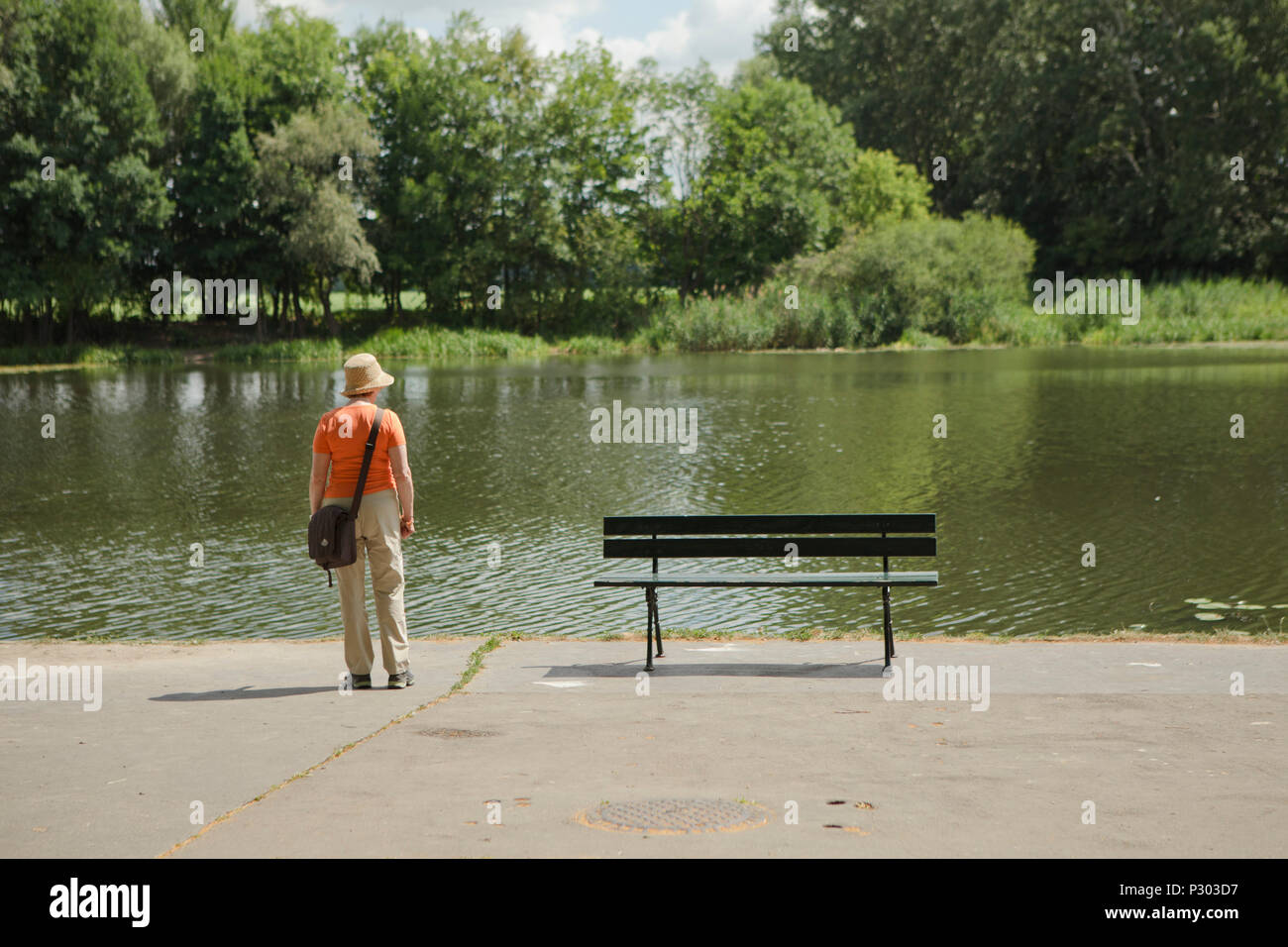 lady and banch over a river in stron summer light Stock Photo - Alamy