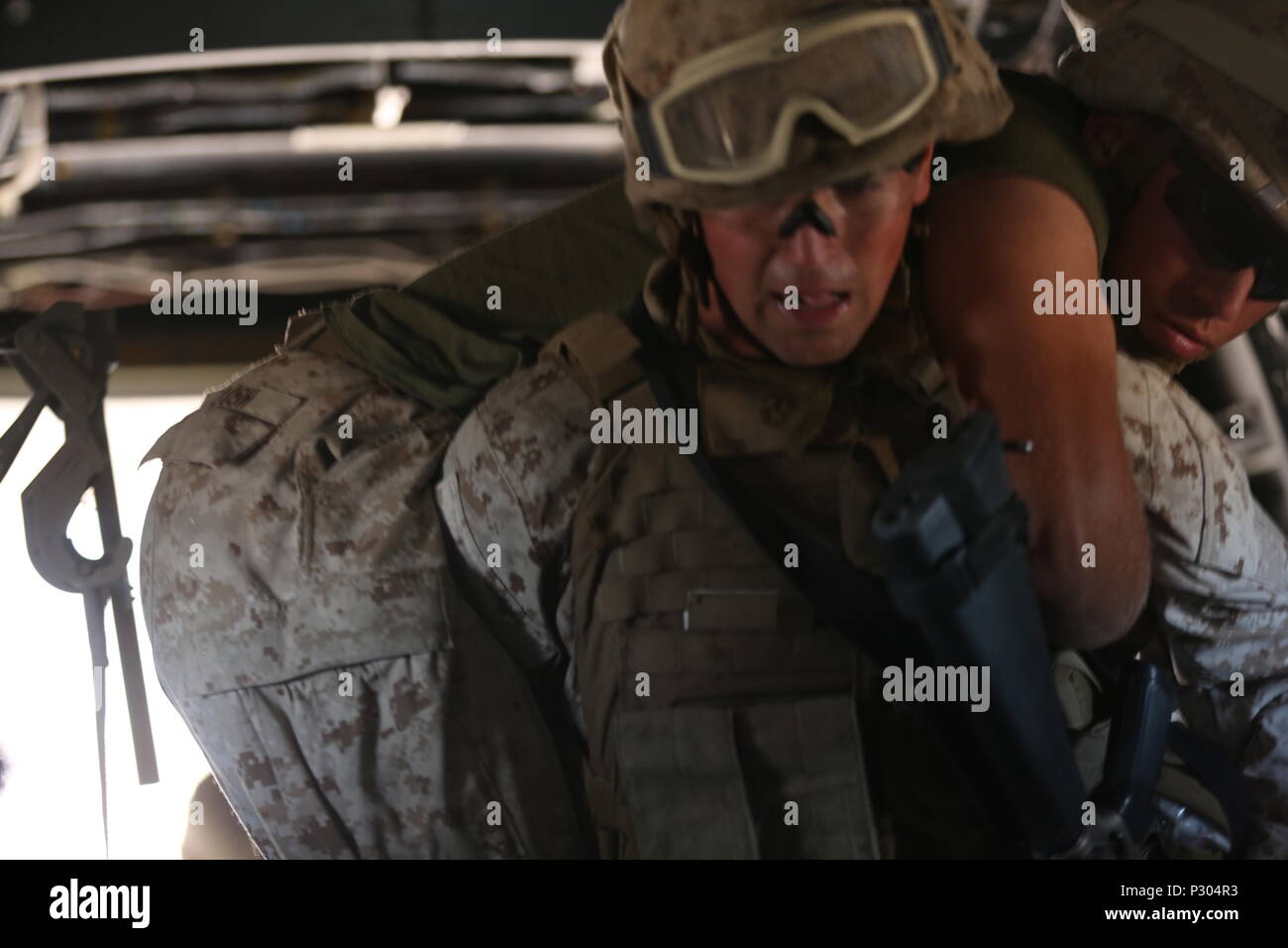 A Marine with 5th Battalion, 11th Marines, loads a simulated casualty ...