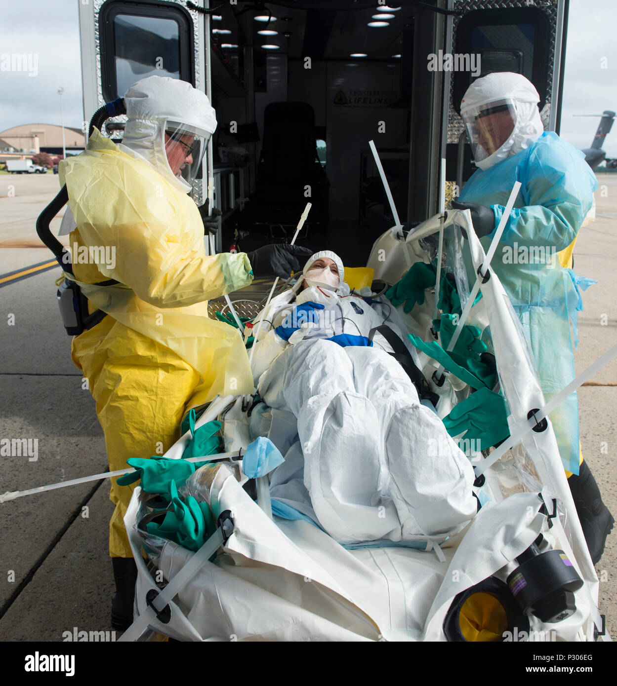 A simulated Ebola patient is placed in an isolation pod by local area ...