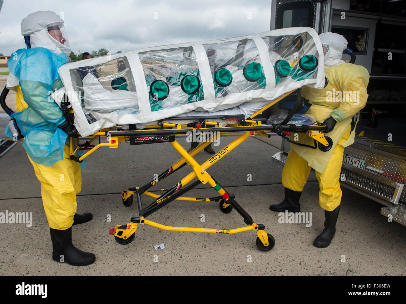 A simulated Ebola patient in an isolation pod is placed in an ambulance ...