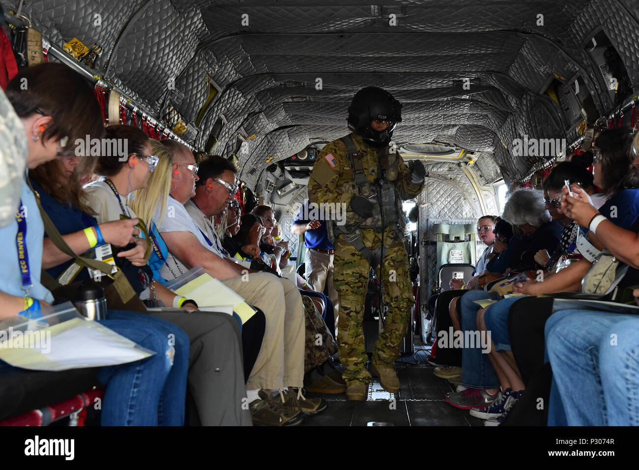 The air crew on a CH-47 Chinook helicopter instructs patients how to ...