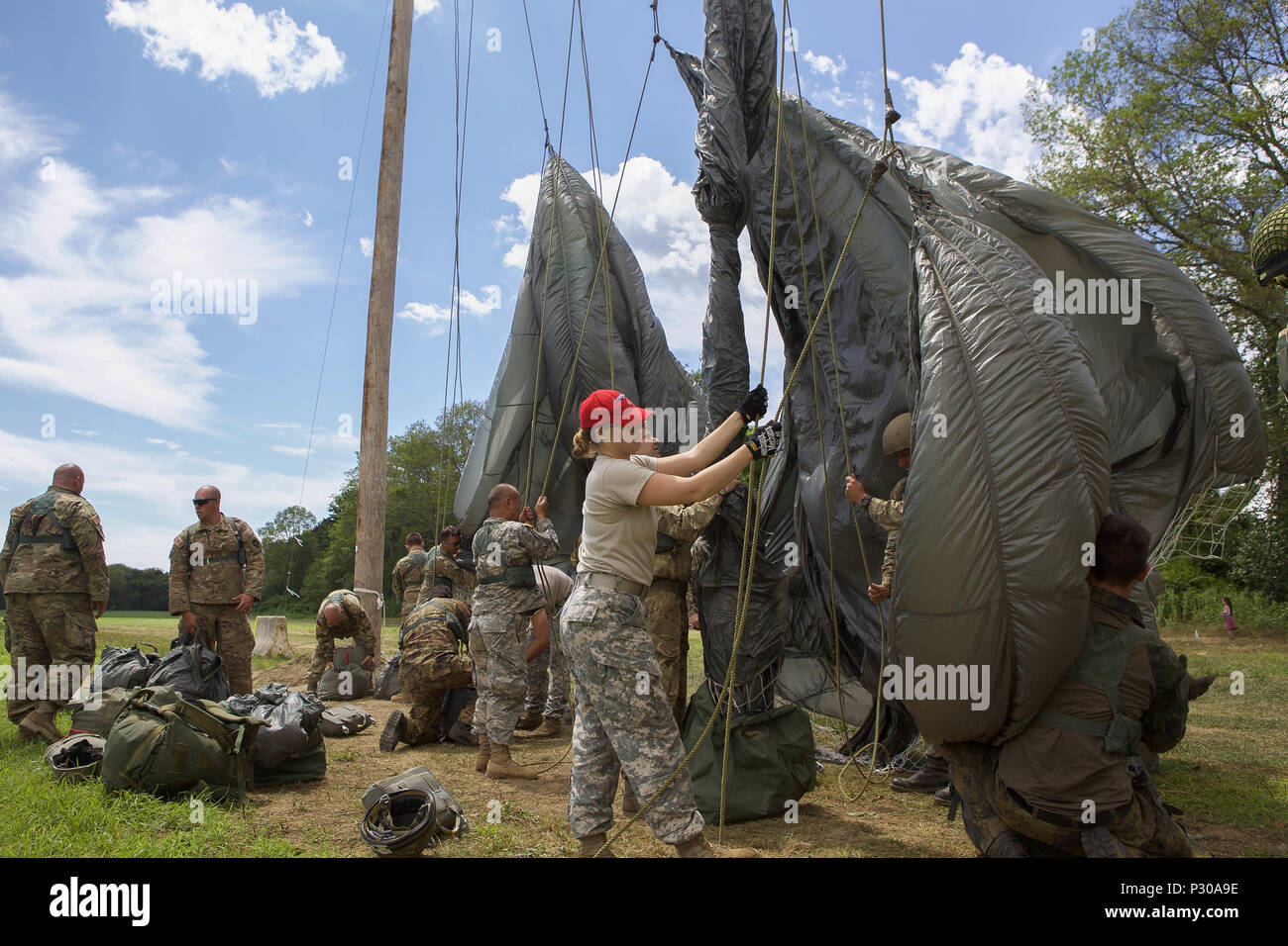 U.S. Army Rigger assist Paratroopers in shaking out their parachutes on ...
