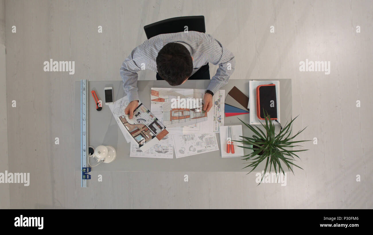 Engineer with blueprints of object and laptop. Top view Stock Photo - Alamy