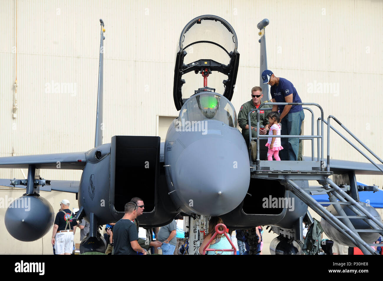 A little girl and her father observe an F-15 Strike Eagle static ...