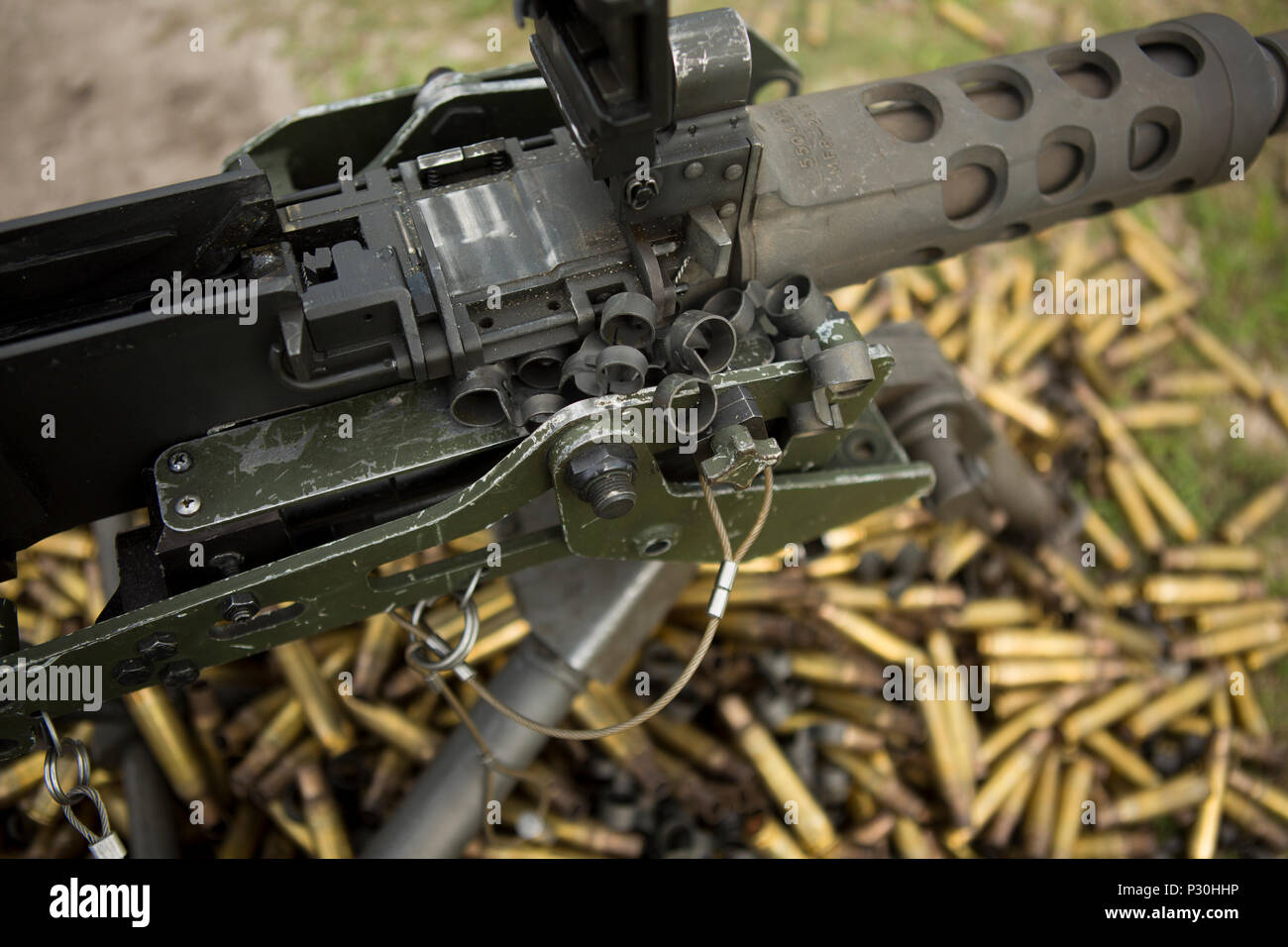 An M2 machine gun sits over fired .50 caliber casings after firing ...