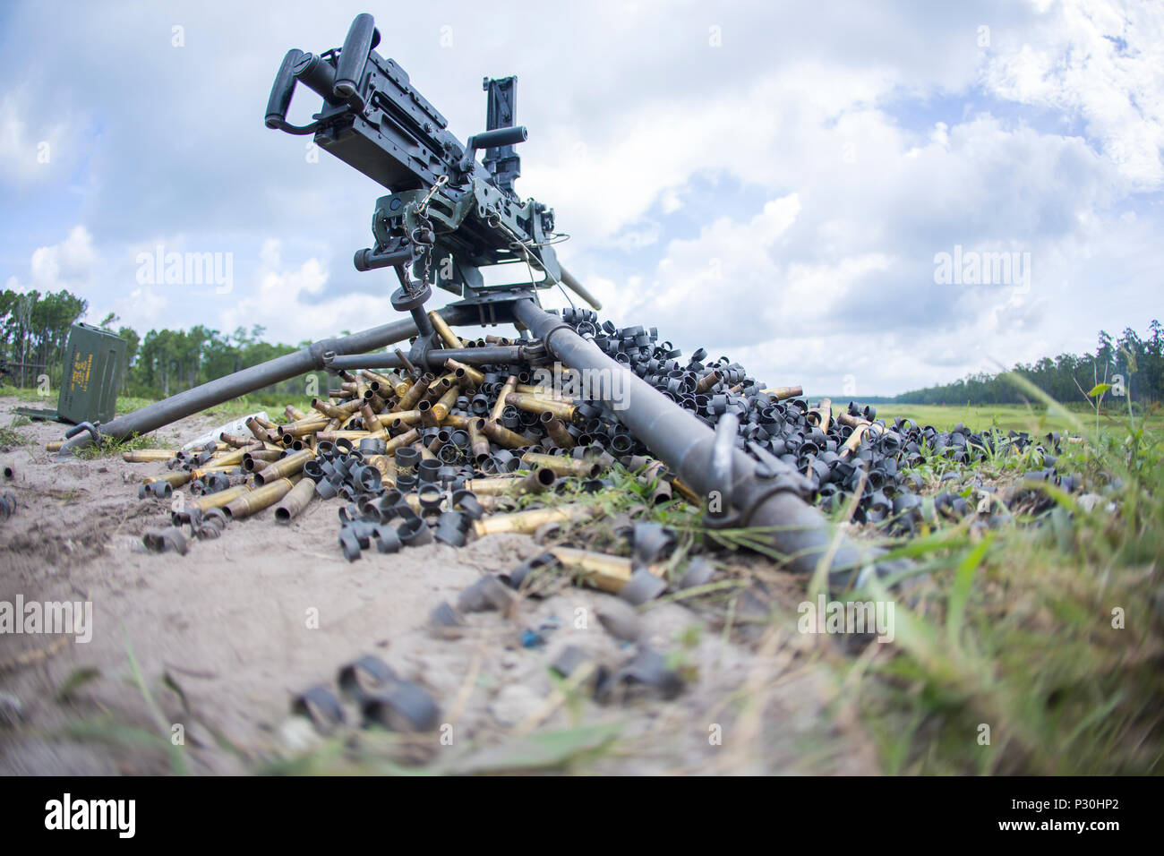 An M2 machine gun lays over fired .50 caliber casings after firing ...