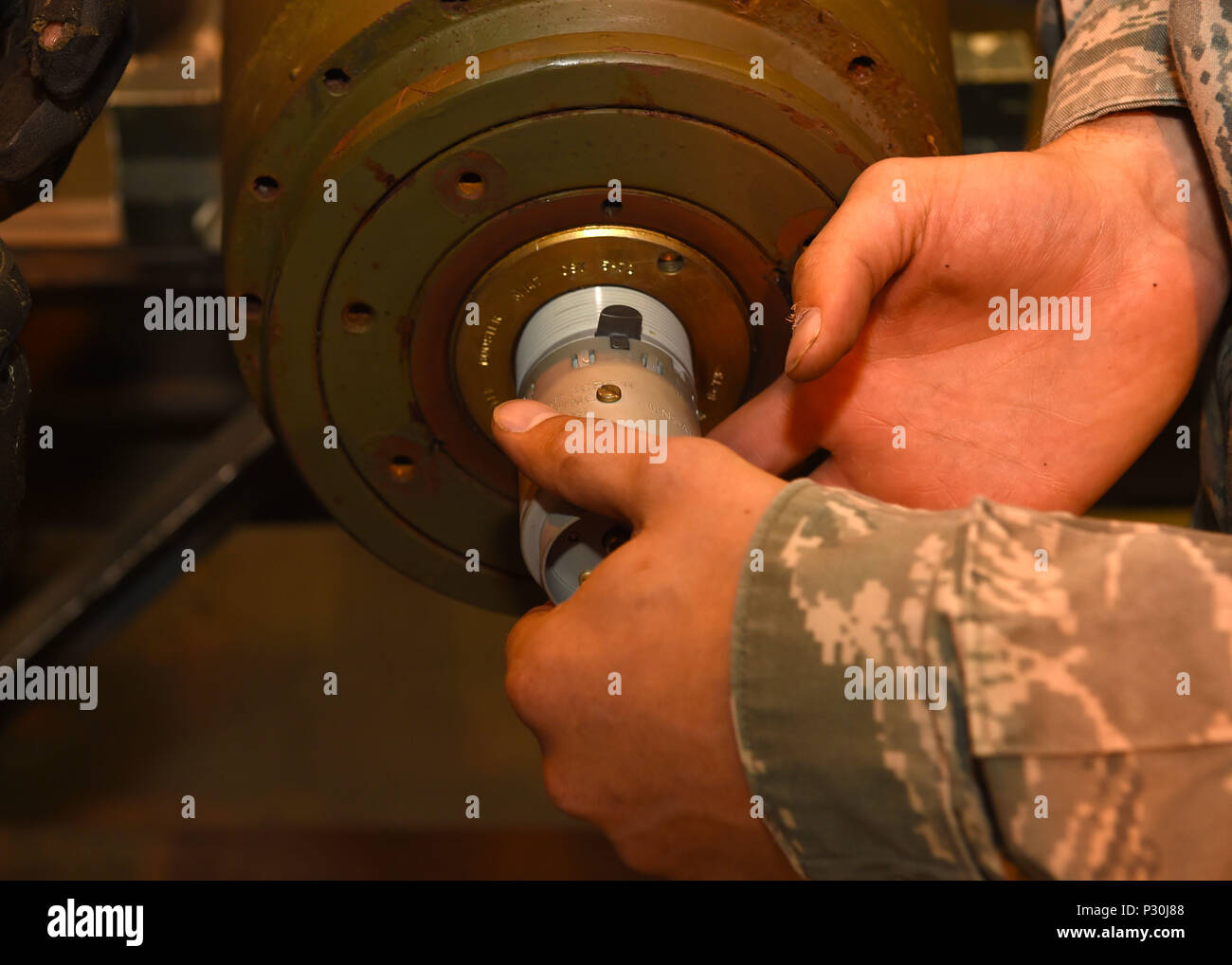 An Airman screws in a tail fuse while assembling a GBU-12 Paveway II ...