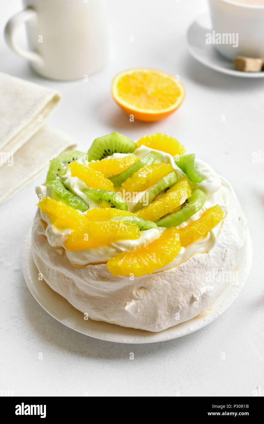 Pavlova meringue cake with kiwi, orange slices and whipped cream Stock ...
