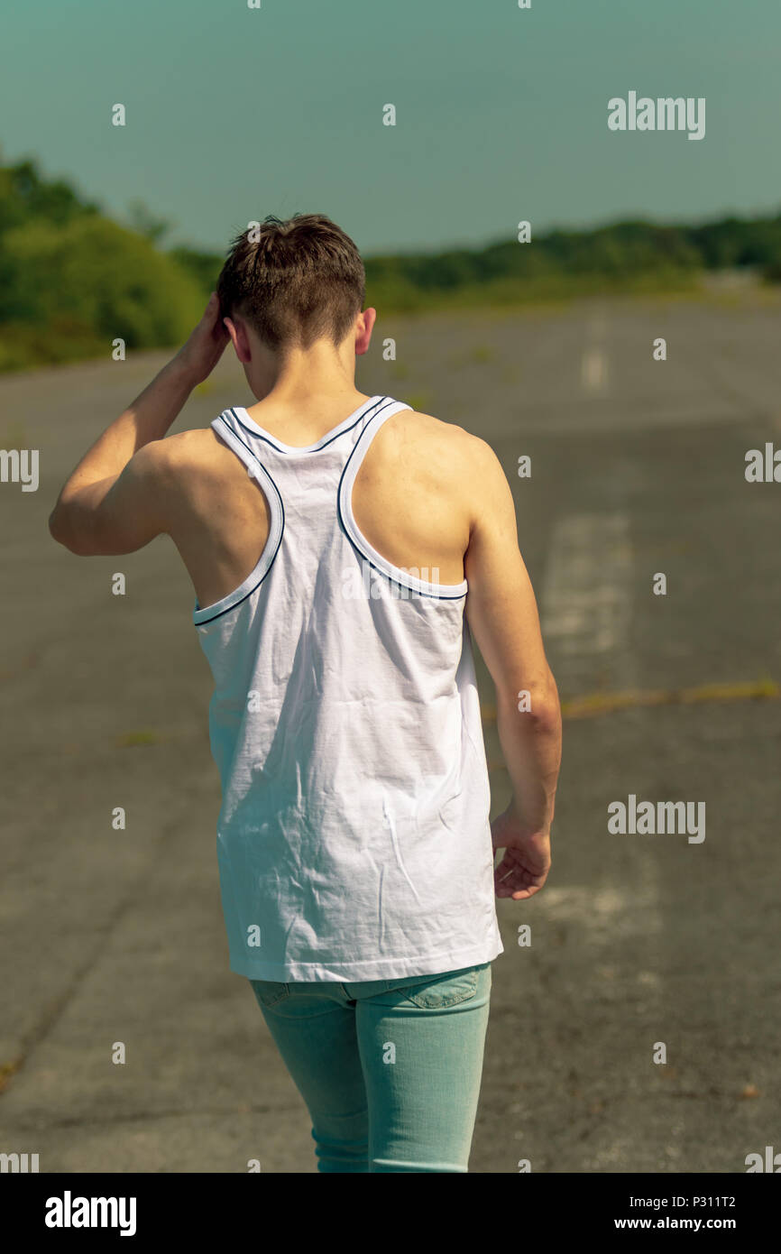 Young adult male walking outside in the sunshine Stock Photo - Alamy