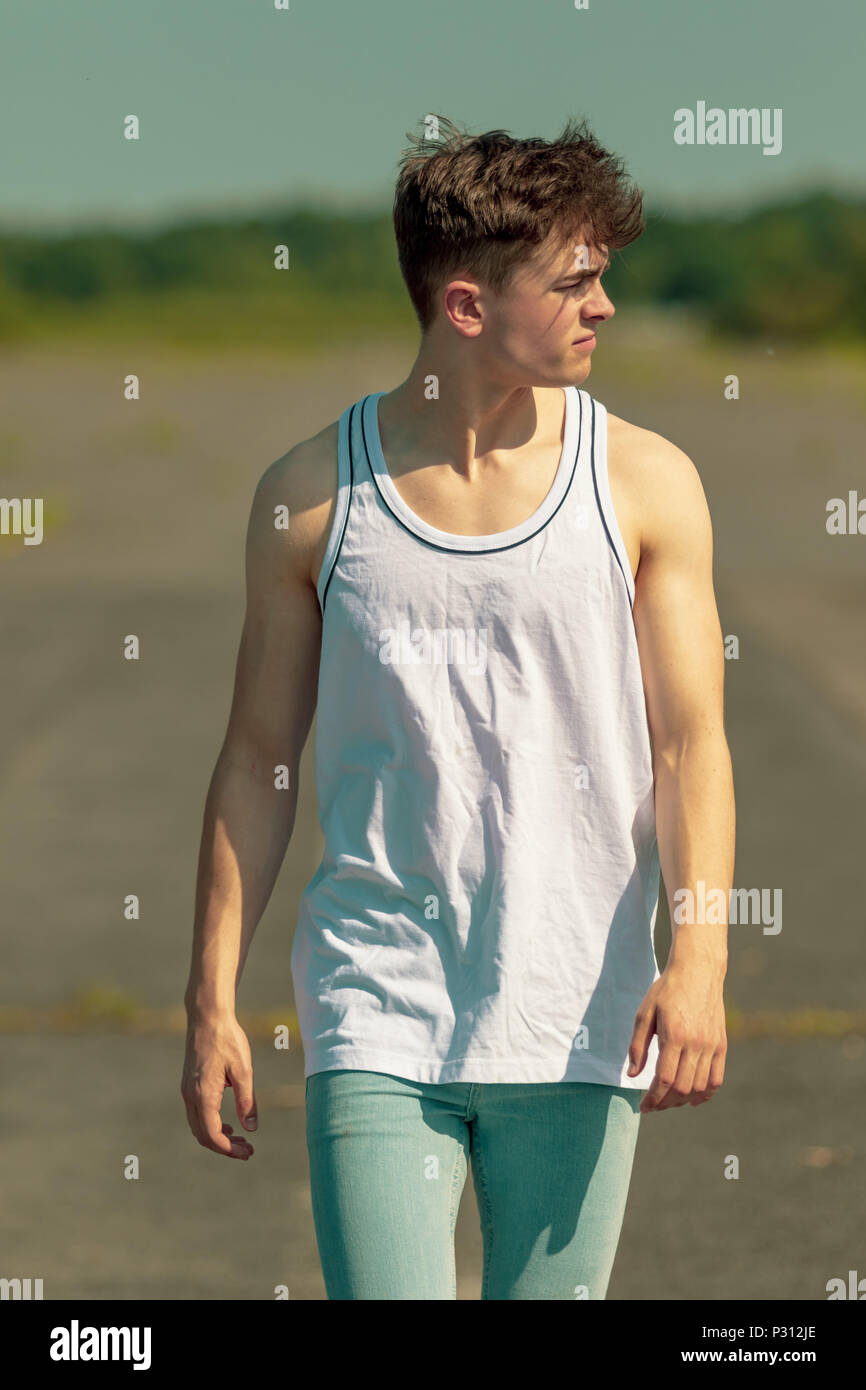 Young adult male walking outside in the sunshine Stock Photo - Alamy