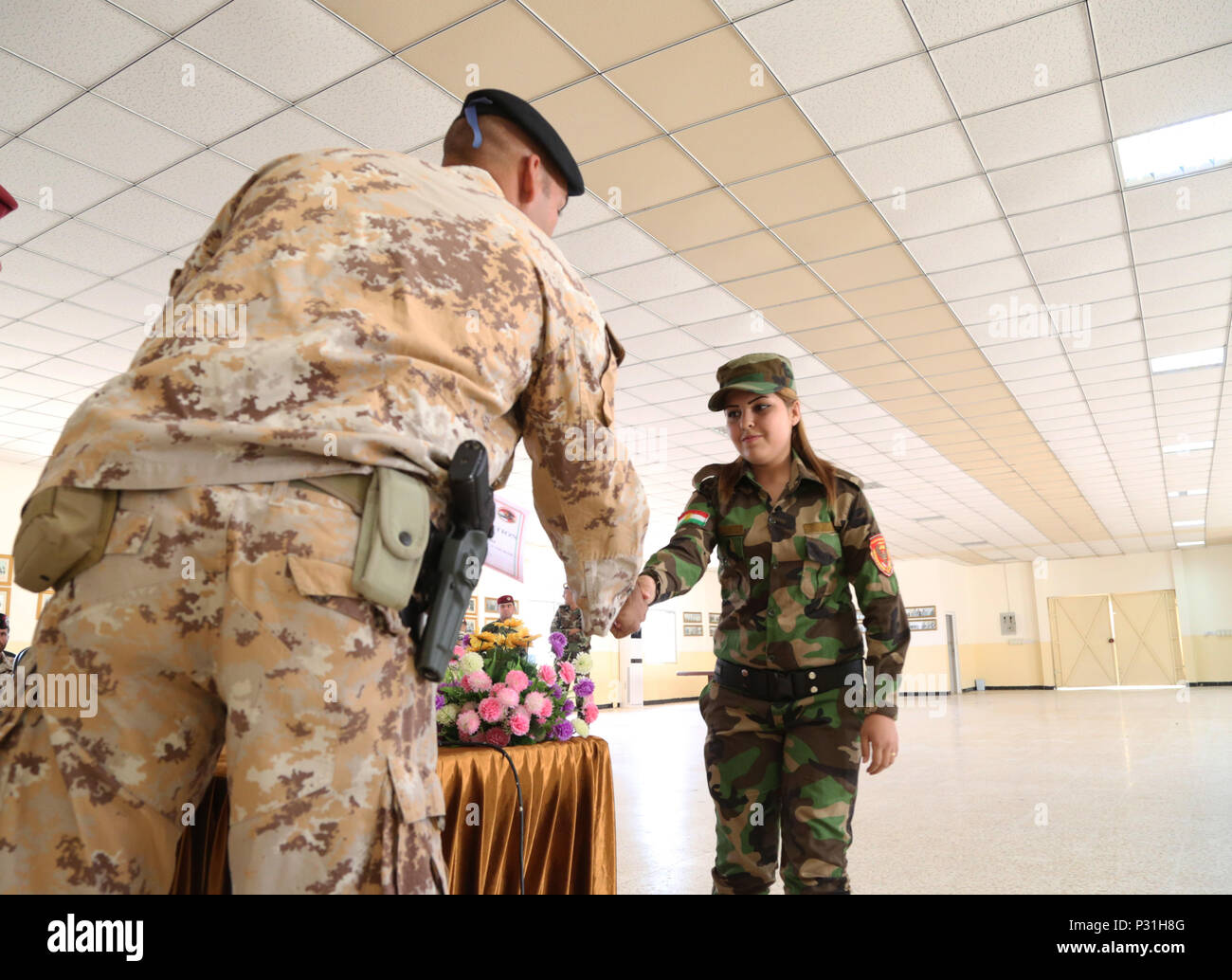 A Zeravani soldier shakes hands with an Italian trainer during a ...