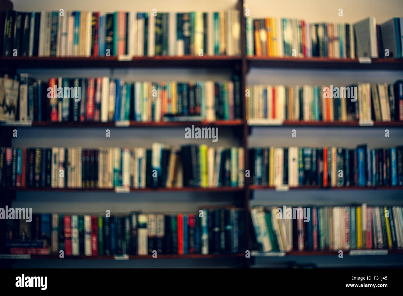 Shelves with books in a blurred background. Abstract colorful blurred ...