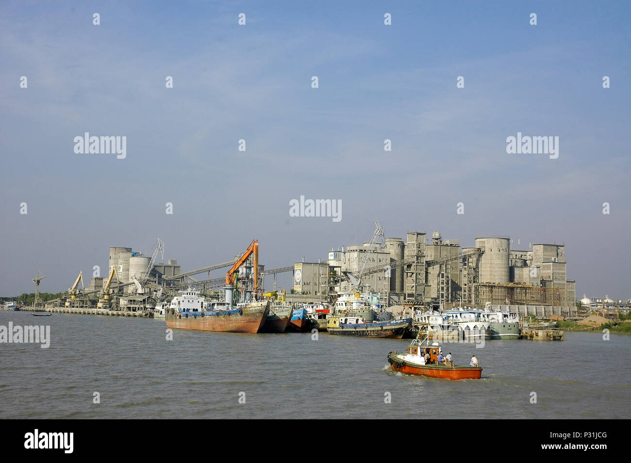 Cement factory on the bank of Pasur River at Mongla. Bagerhat ...