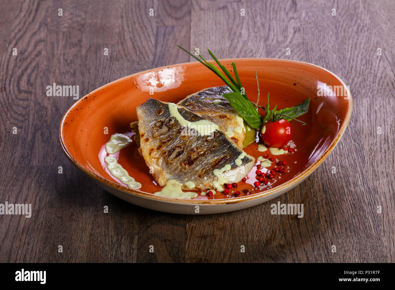 Grilled dorada fillet served tomato and onion Stock Photo - Alamy