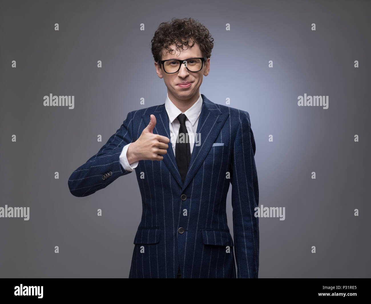 Funny man in striped suit showing thumbs up over gray background ...