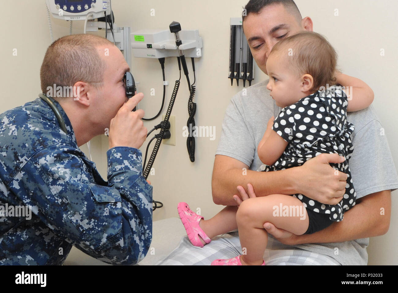 Lt. Chad Lomas, pediatrician, Naval Hospital Pensacola, exams an infant ...