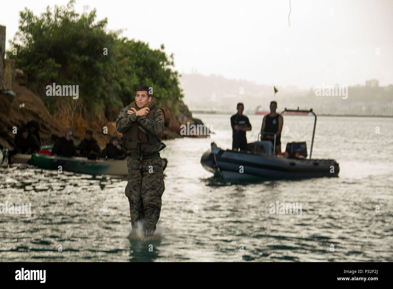 Cpl. Aaron L. Becker, a rifleman, jumps off a bridge into the ocean ...