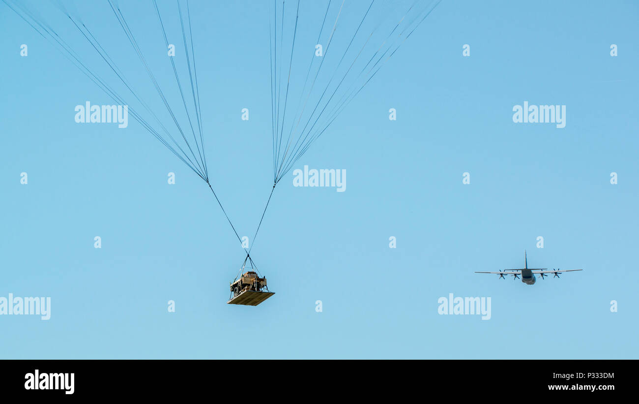 Equipment parachutes from a C-130 Hercules during a joint airborne ...