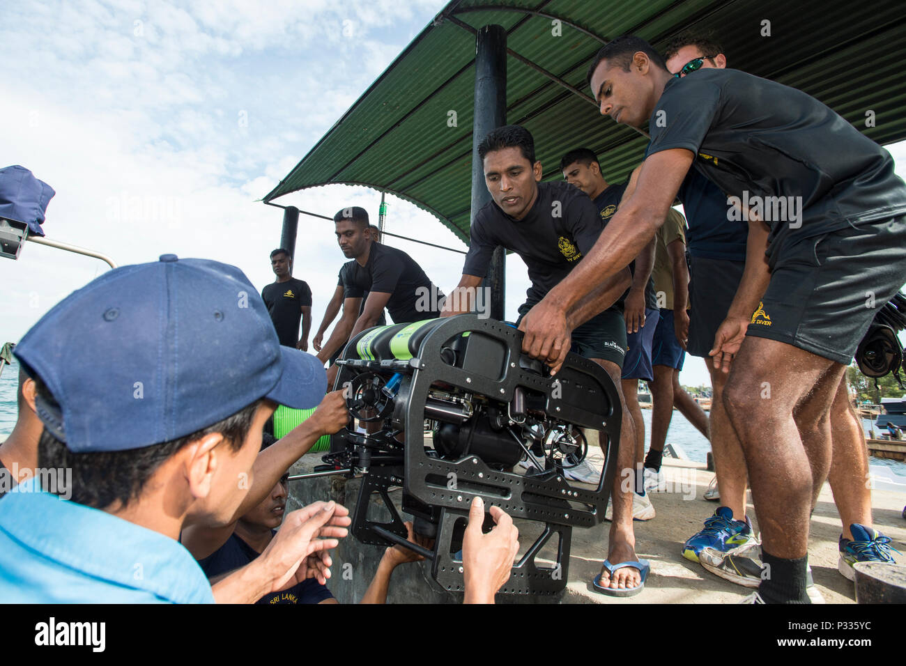 Sri Lankan Navy divers handle a SeaBotix remotely operated vehicle ...